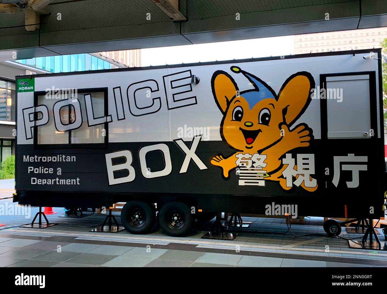 A trailer house type police box is installed in front of a station near ...