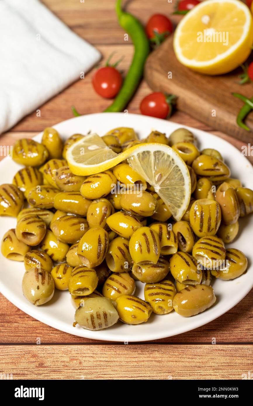 Grilled olives. Special green olives on a wood background ...
