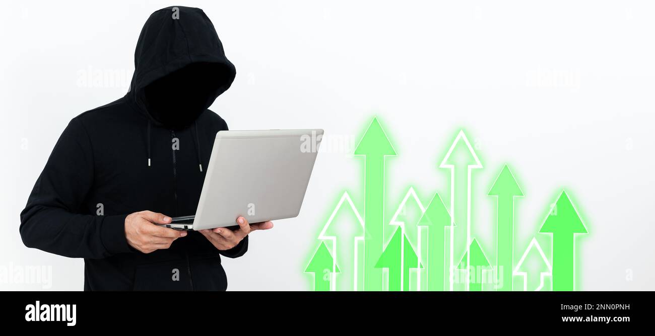 Male programmer in black hoodie stands and holds laptop. Hacker with ...