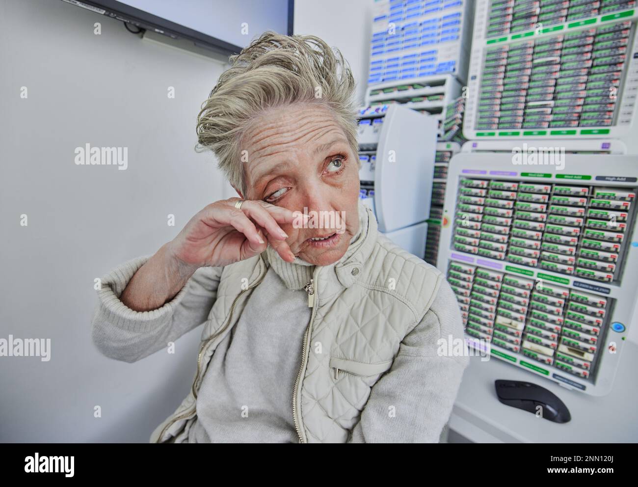 Elderly woman, ophthalmology and eye pain with hand in clinic ...