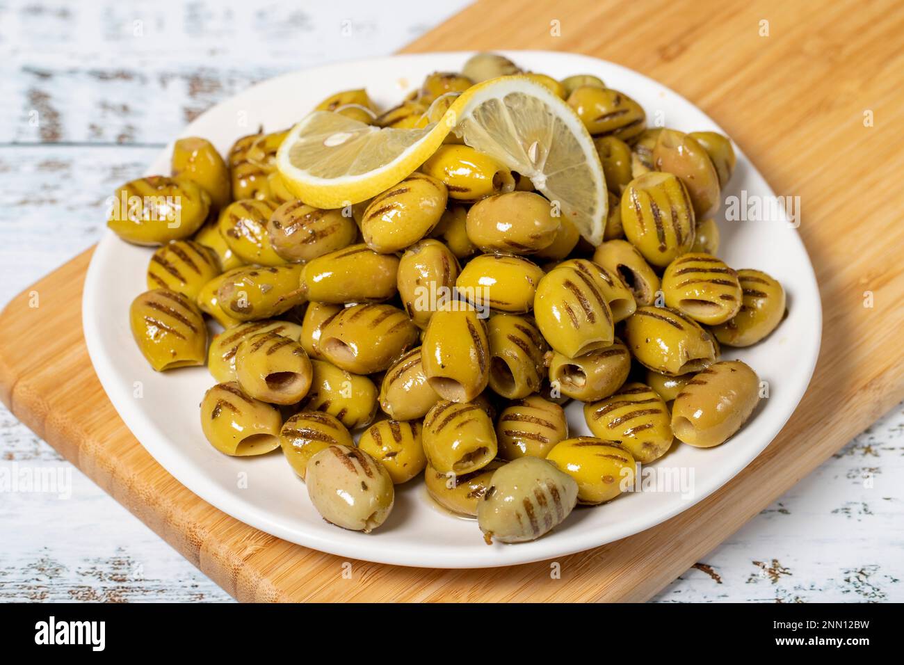 Grilled olives. Special green olives on a wood background ...