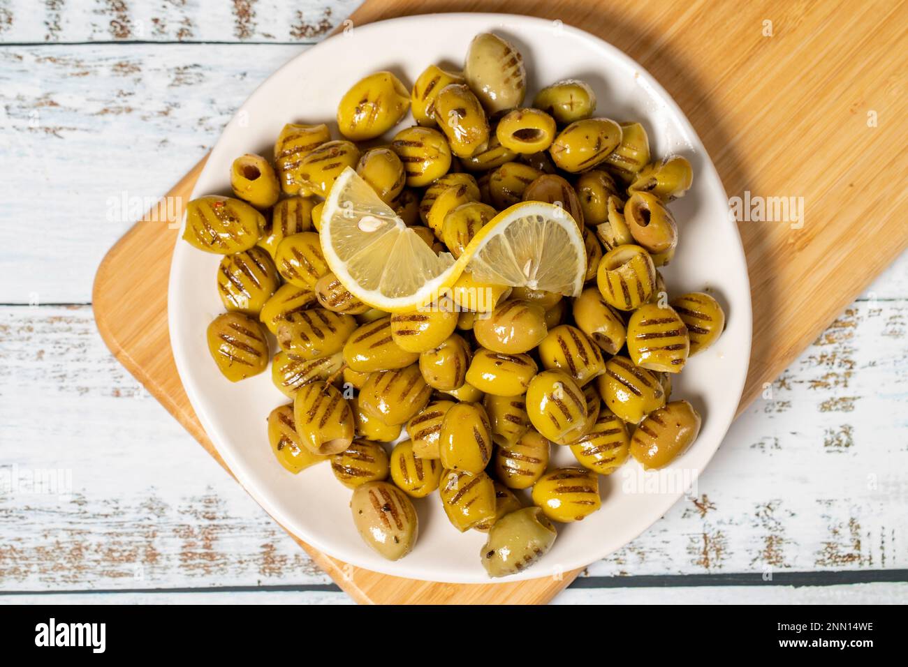 Grilled olives. Special green olives on a wood background ...