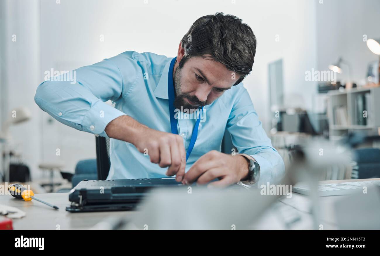 Laptop, repair and concentration with an engineer or handyman fixing ...