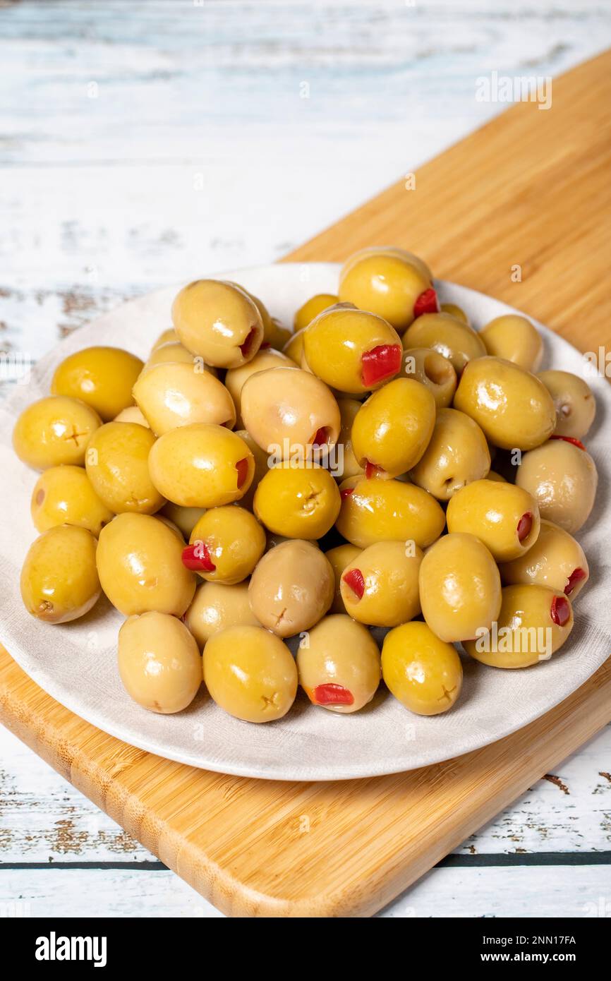 Stuffed olives. Green olives stuffed with dry peppers on a wooden ...
