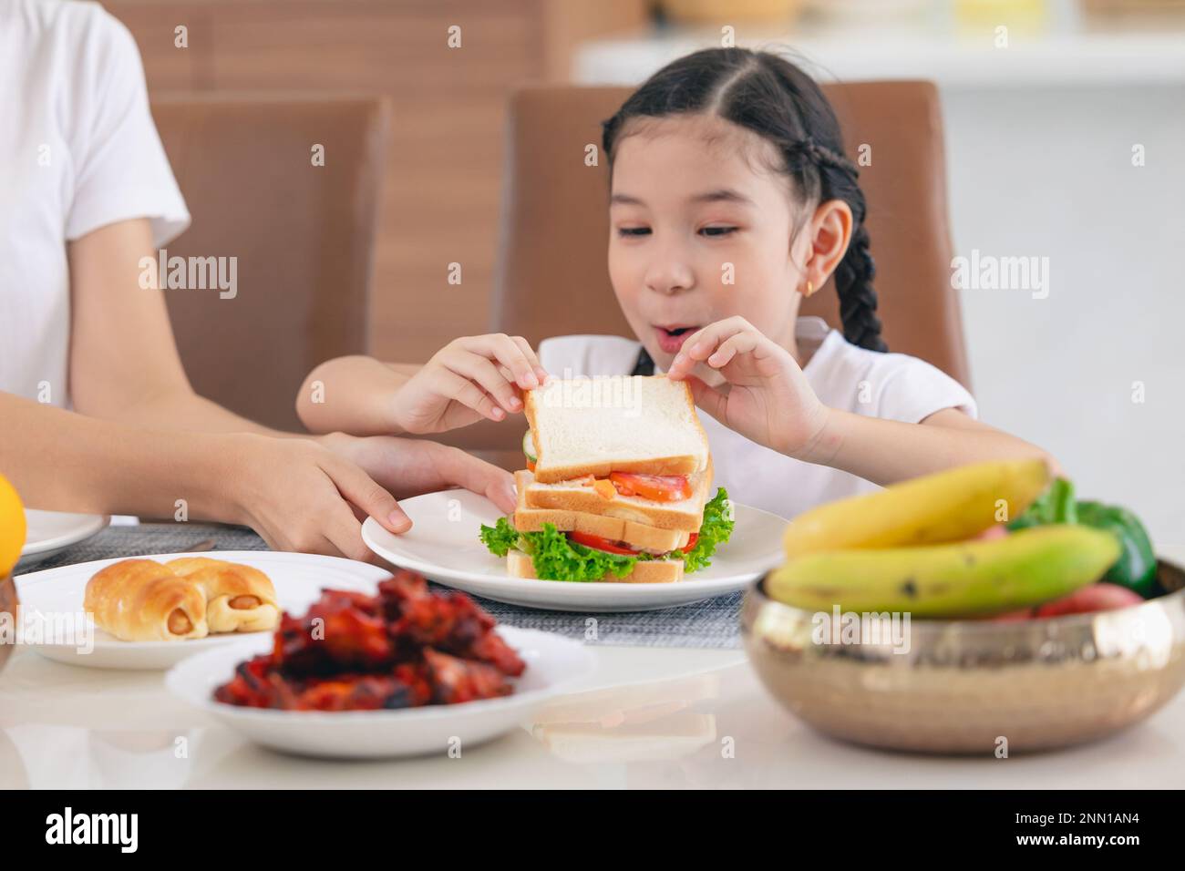 Asian cute daughter happy enjoy eating healthy food morning meal ...