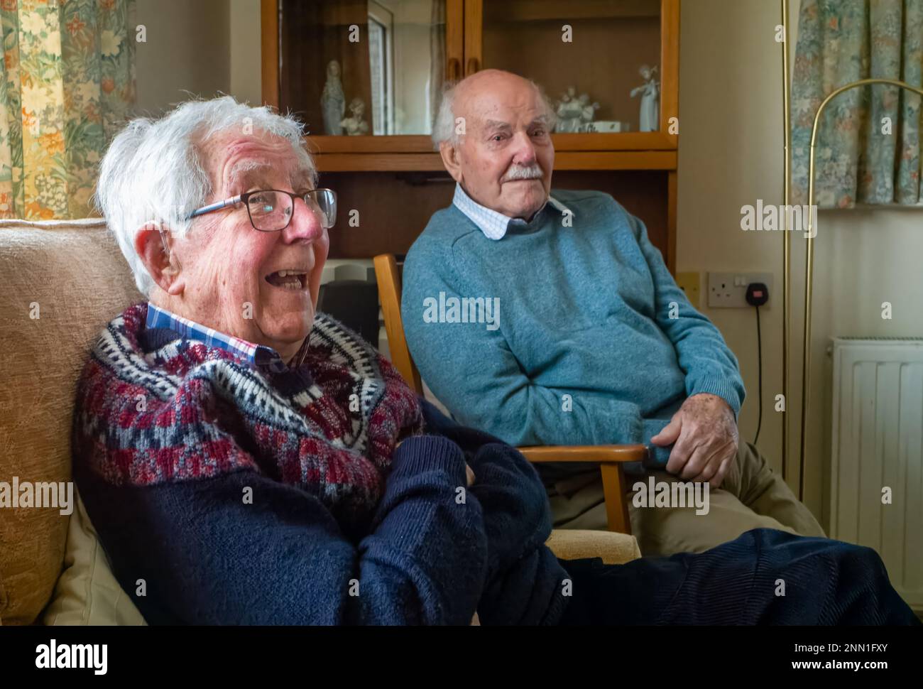 Two elderly men in their 90s who are lifelong friends sit and chat ...