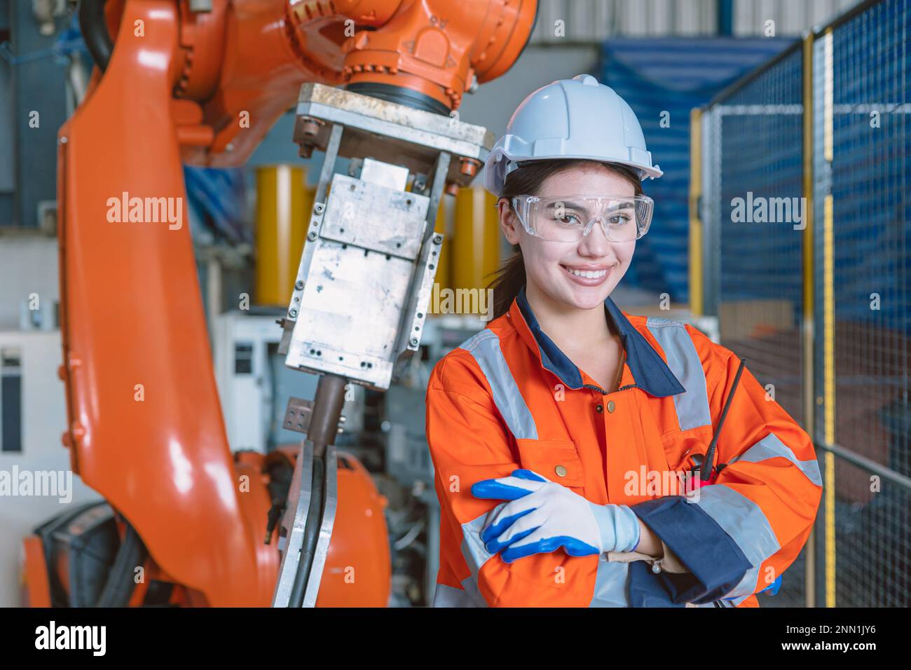portrait happy woman worker with robot assembly machine in modern metal ...