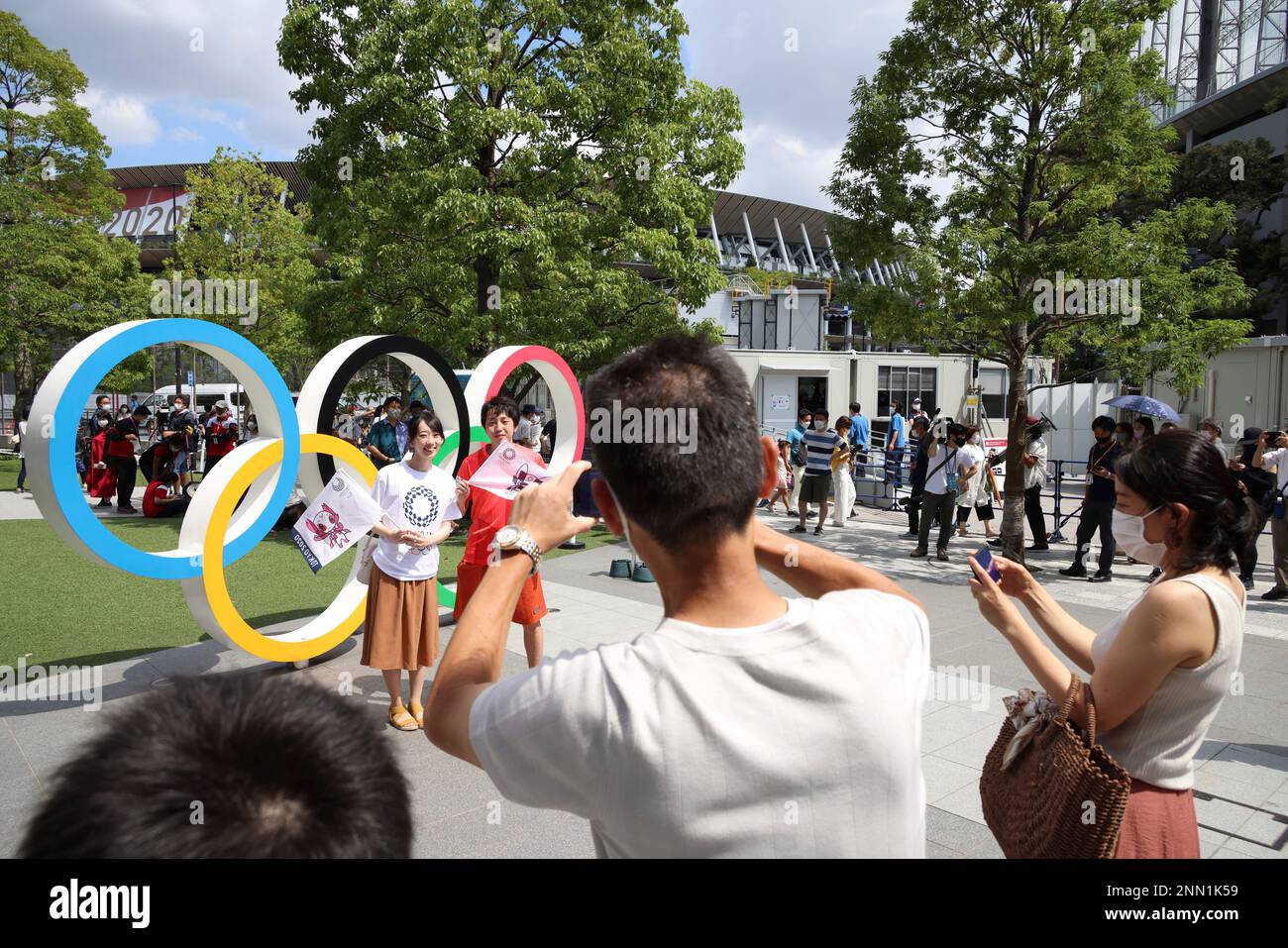 Visitors pose with an Olympic Five-Ring emblem with the National ...