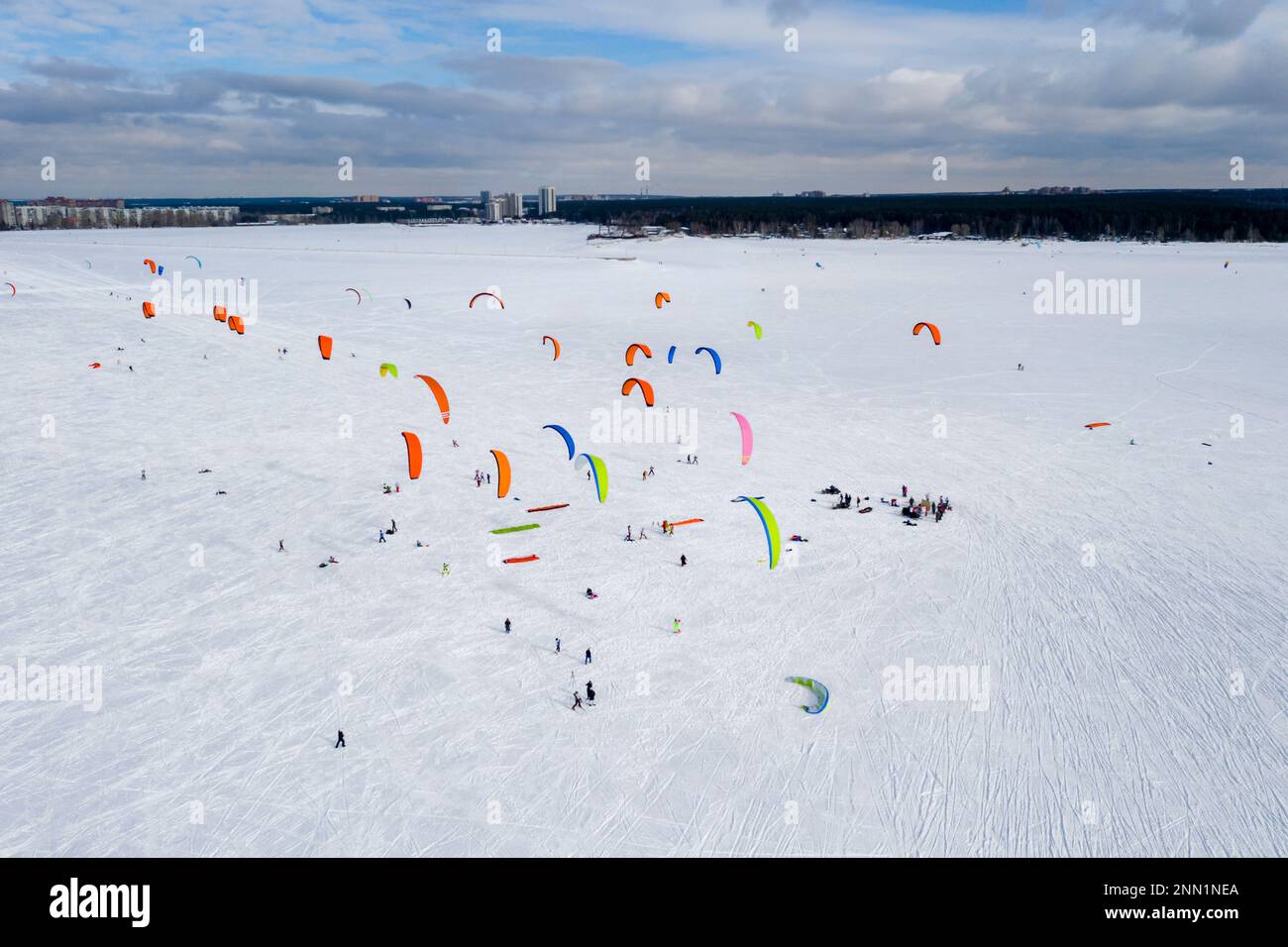 Aerial view of snowkiting competitions with colored parachutes on a ...