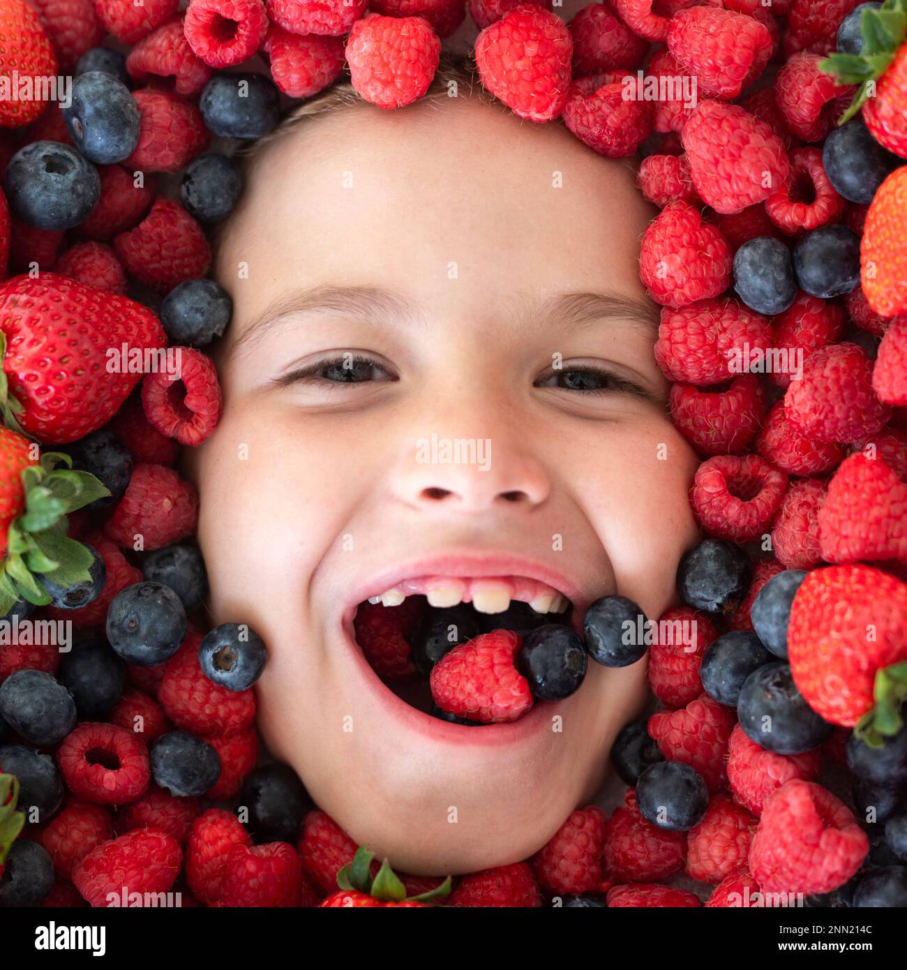 Healthy eating. Mix of berries. Kids face with fresh berries fruits ...