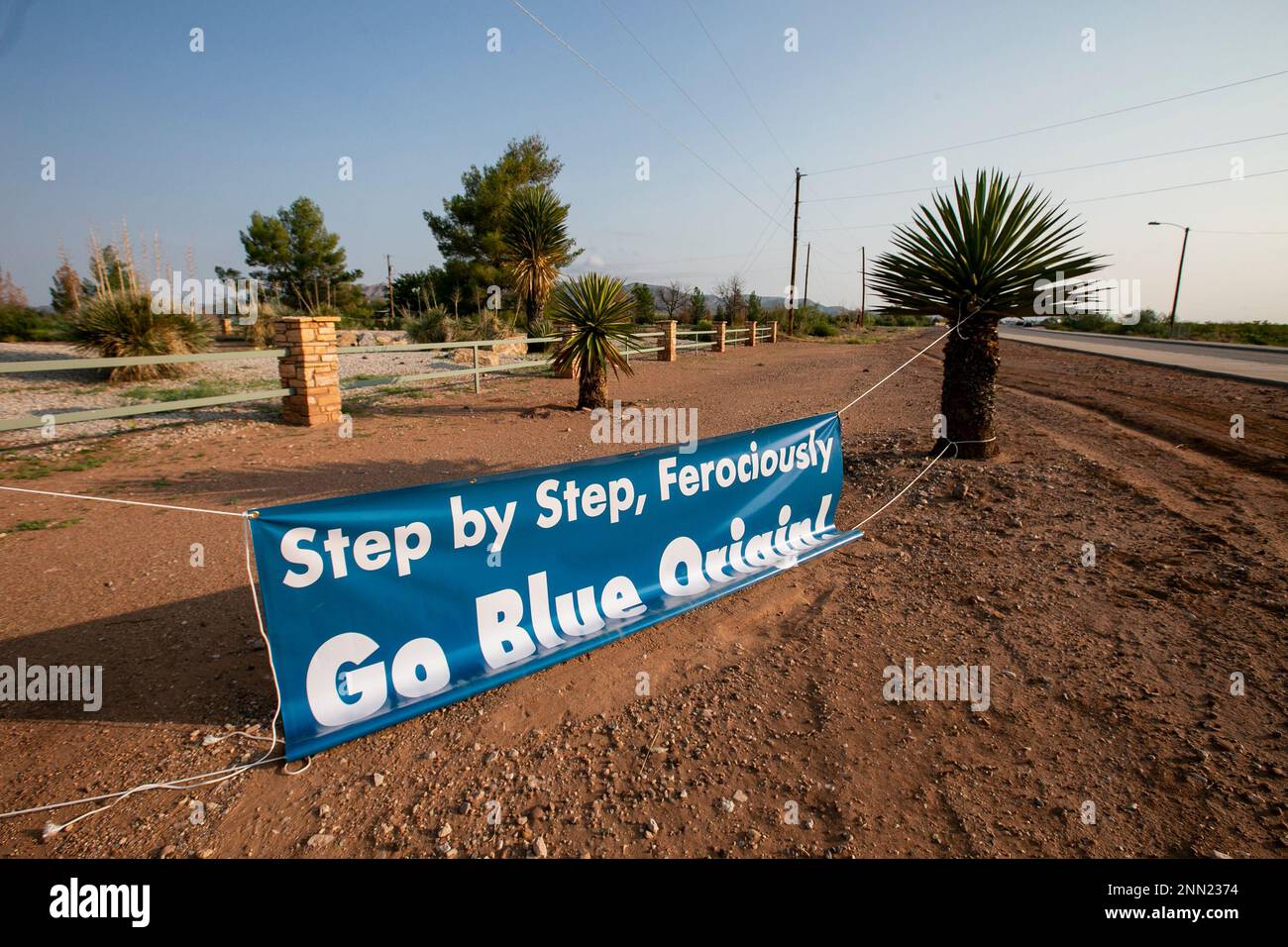 A sign reads "Step by Step, Ferociously Go Blue Origin!" on the side of ...