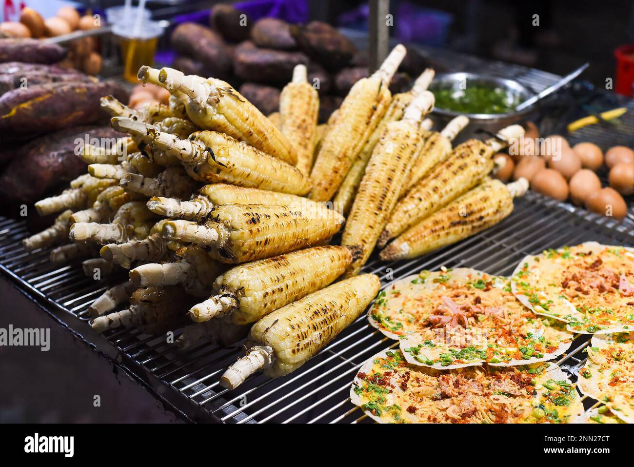 Grilled corn near vietnamese pancake with eggs, sausages and sauces in ...