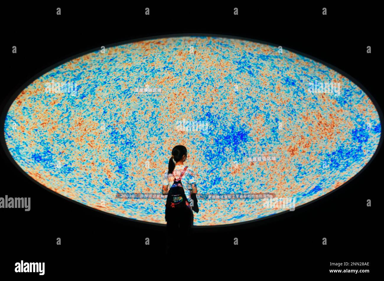 A girl stops by an image of the cosmic microwave background (CMB) at ...