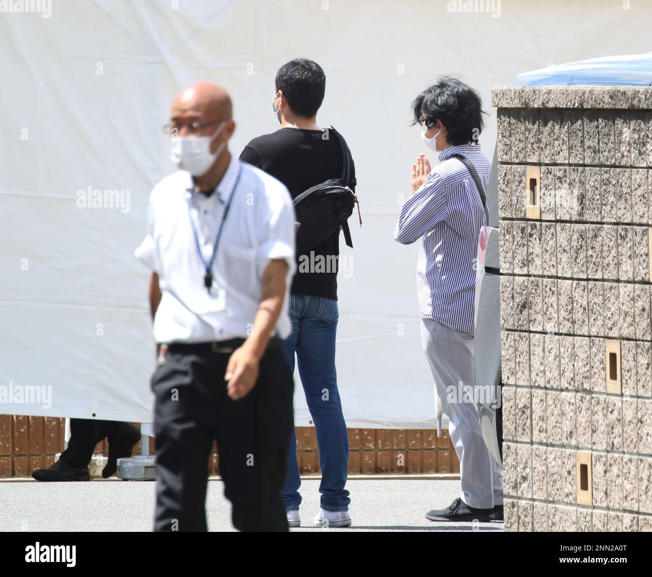 People pray for the victims near a site where the first studio of Kyoto ...