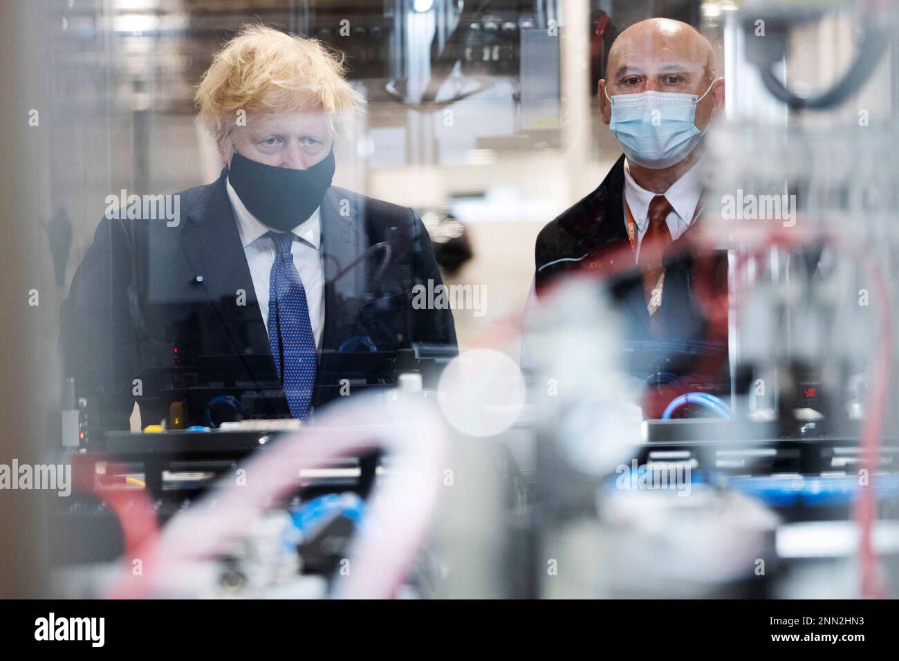 Britain's Prime Minister Boris Johnson, left, listens to managing ...