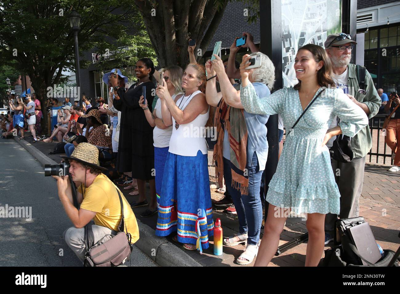 People hold up phones to take photos and record as the statue of George ...