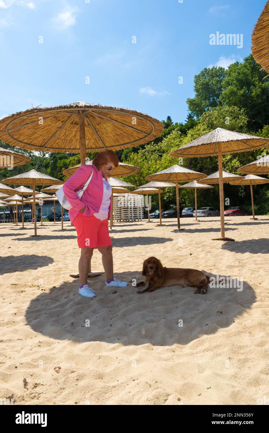 Senior Elegant 73 Years Old Lady Standing Under Beach Parasol With Her