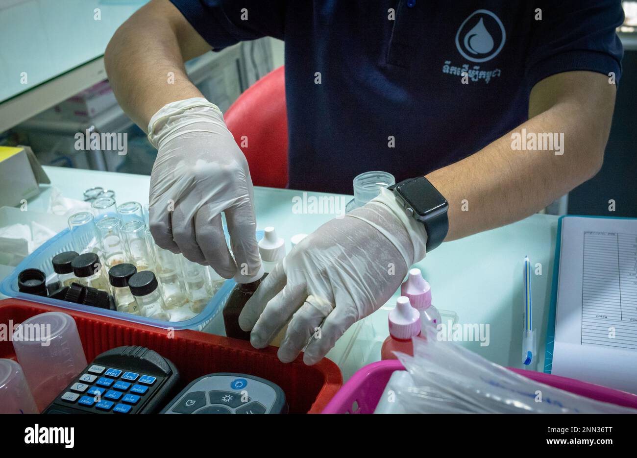 A lab technician tests a sample for water purity at the offices of ...