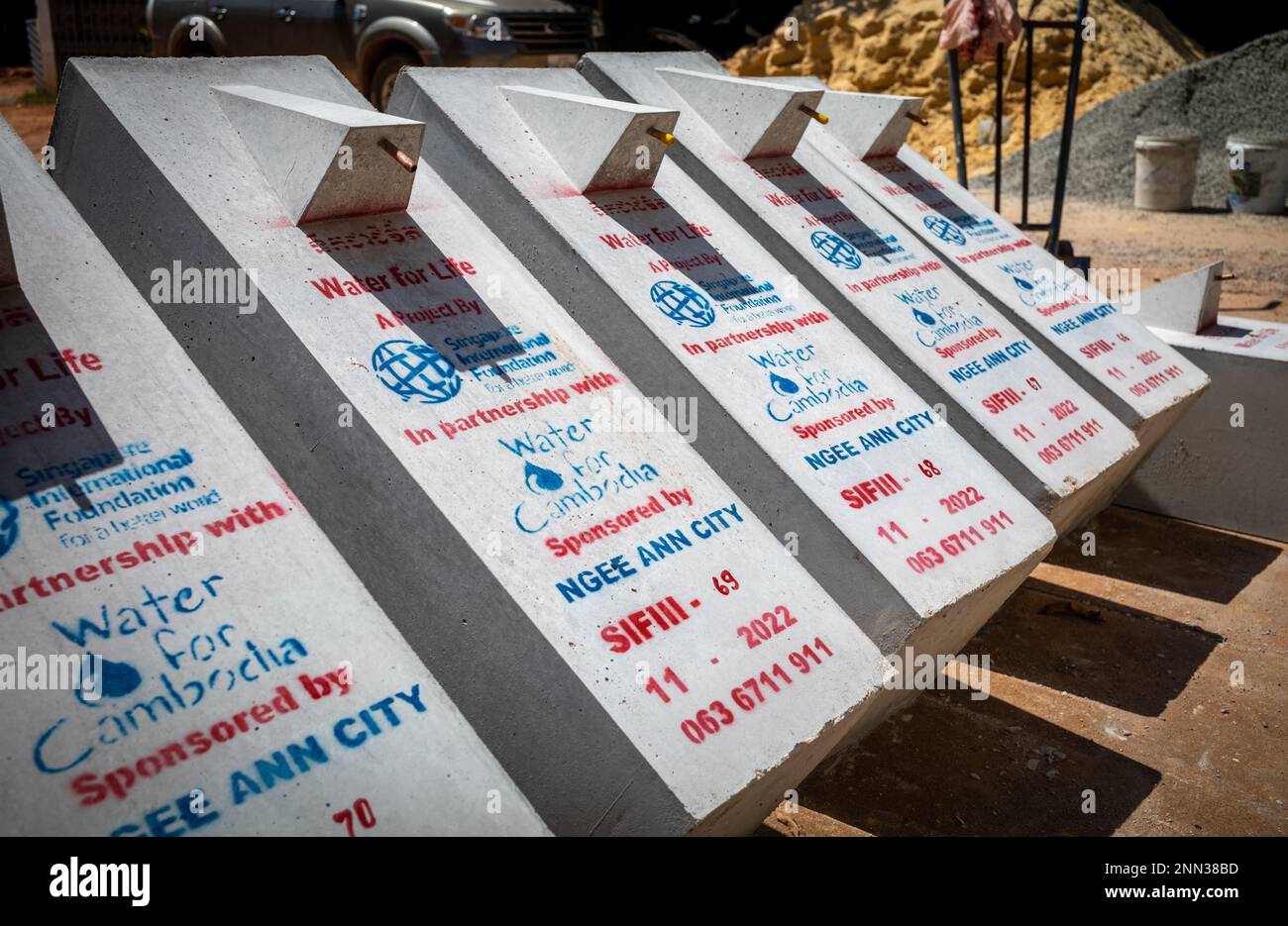 A row of biosand water filters awaiting finishing in the front yard of ...