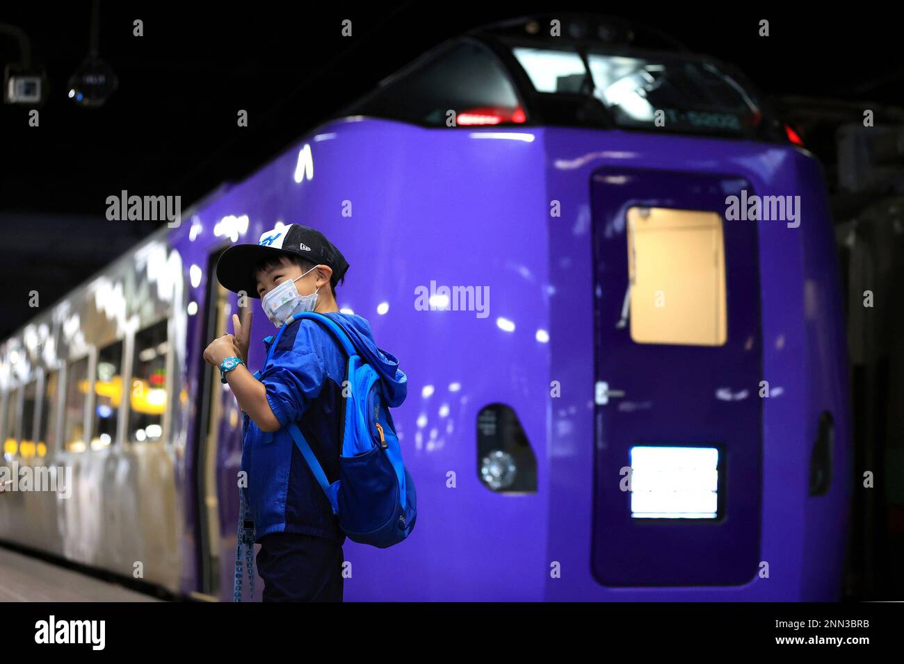 Railway buff boy poses in front of the Furano Lavender Express at JR ...