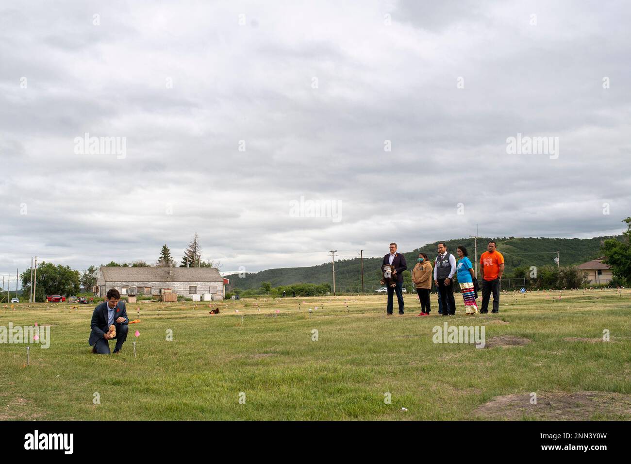 Prime Minister Justin Trudeau, left, lays a teddy bear at a small flag ...