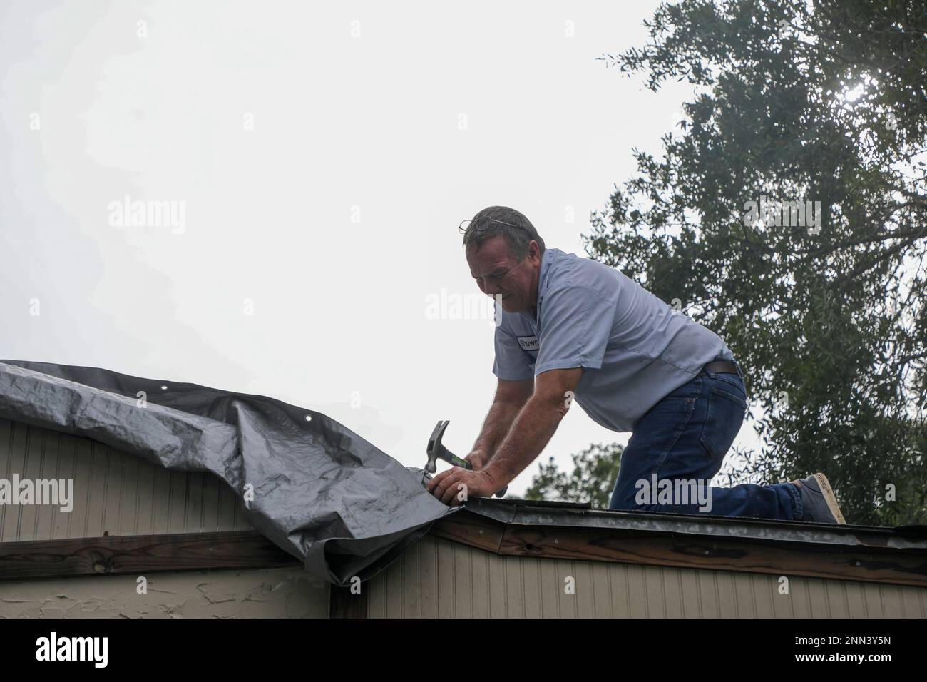 Shawn Frazier, 61, reinforces tarps over his Tampa home's roof ahead of ...