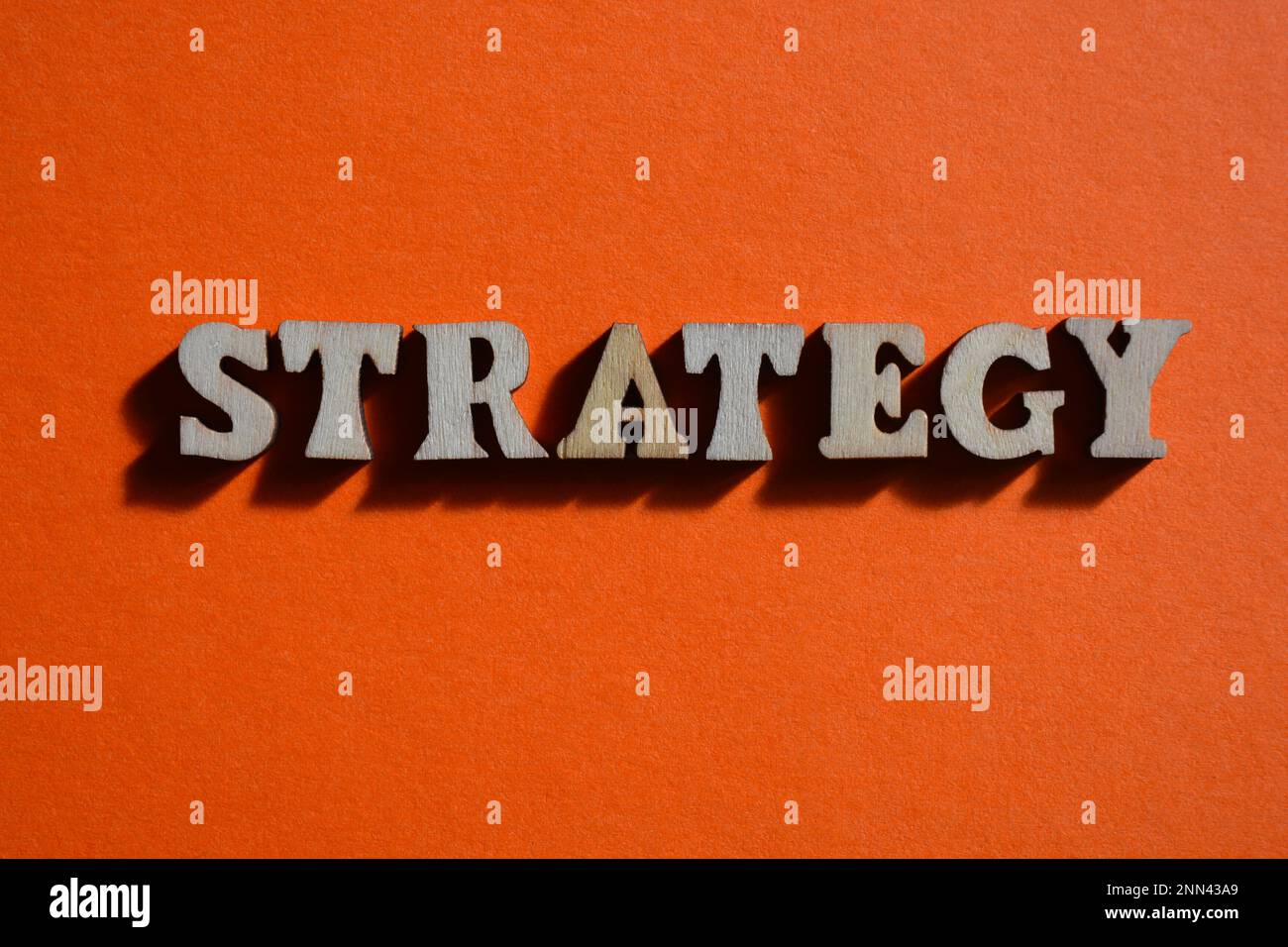Strategy, word in wooden alphabet letters isolated on orange background ...