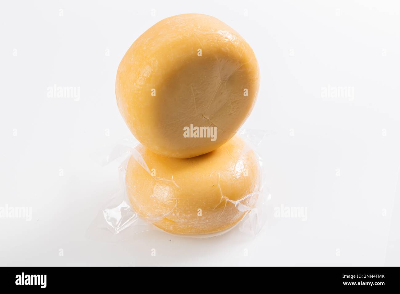 A piece of homemade vacuumed traditional Bosnian cheese isolated on a ...