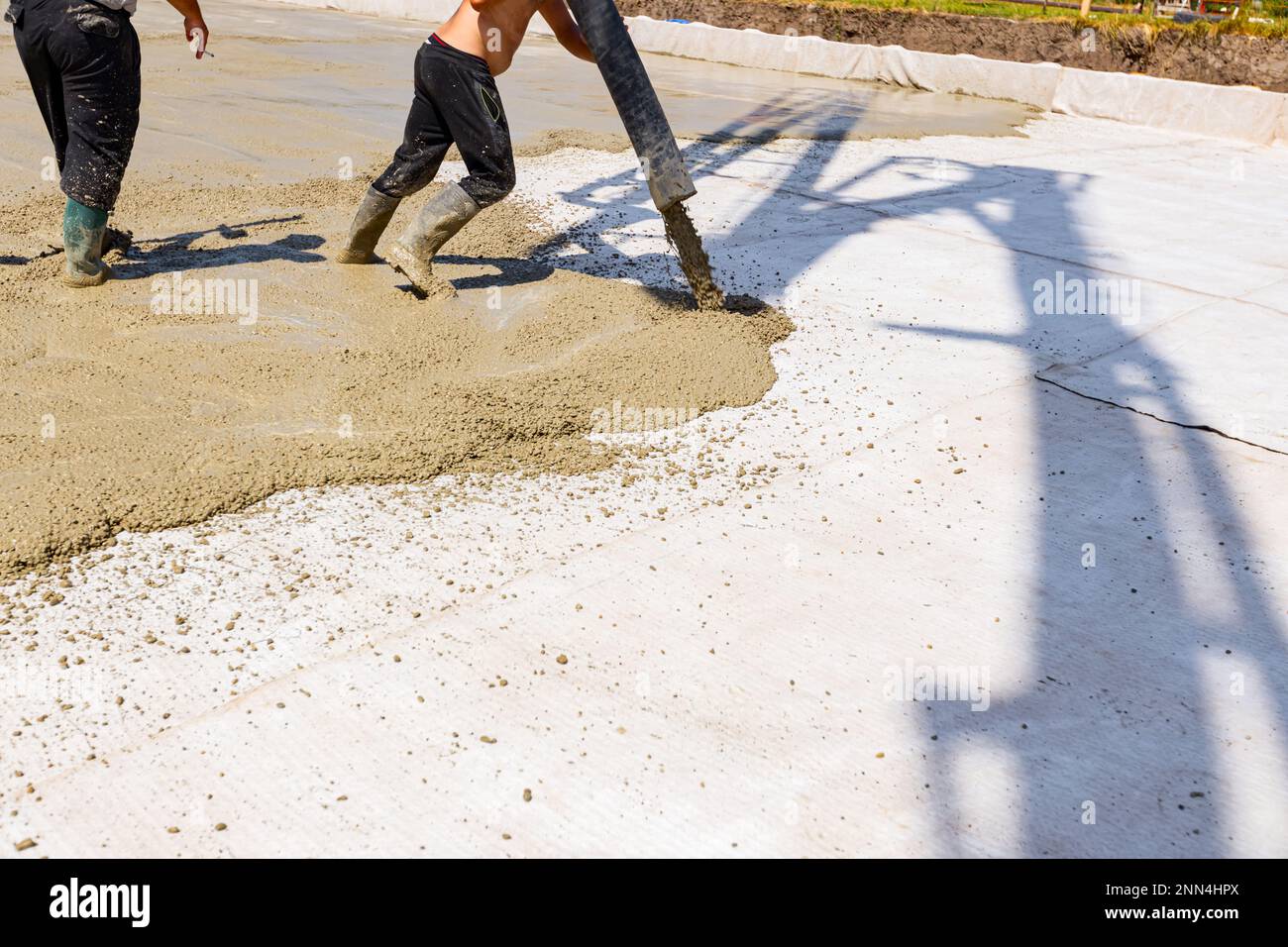 Construction worker is directing the pump tube on right direction ...