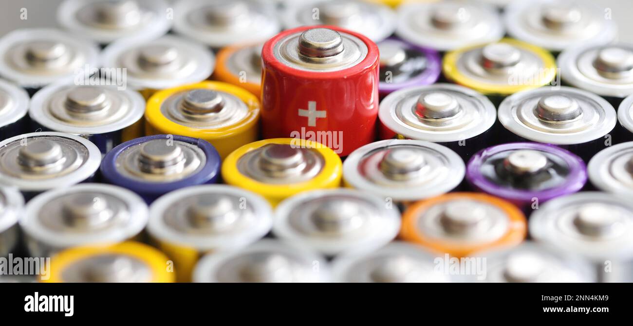 many round batteries and one red battery Stock Photo - Alamy