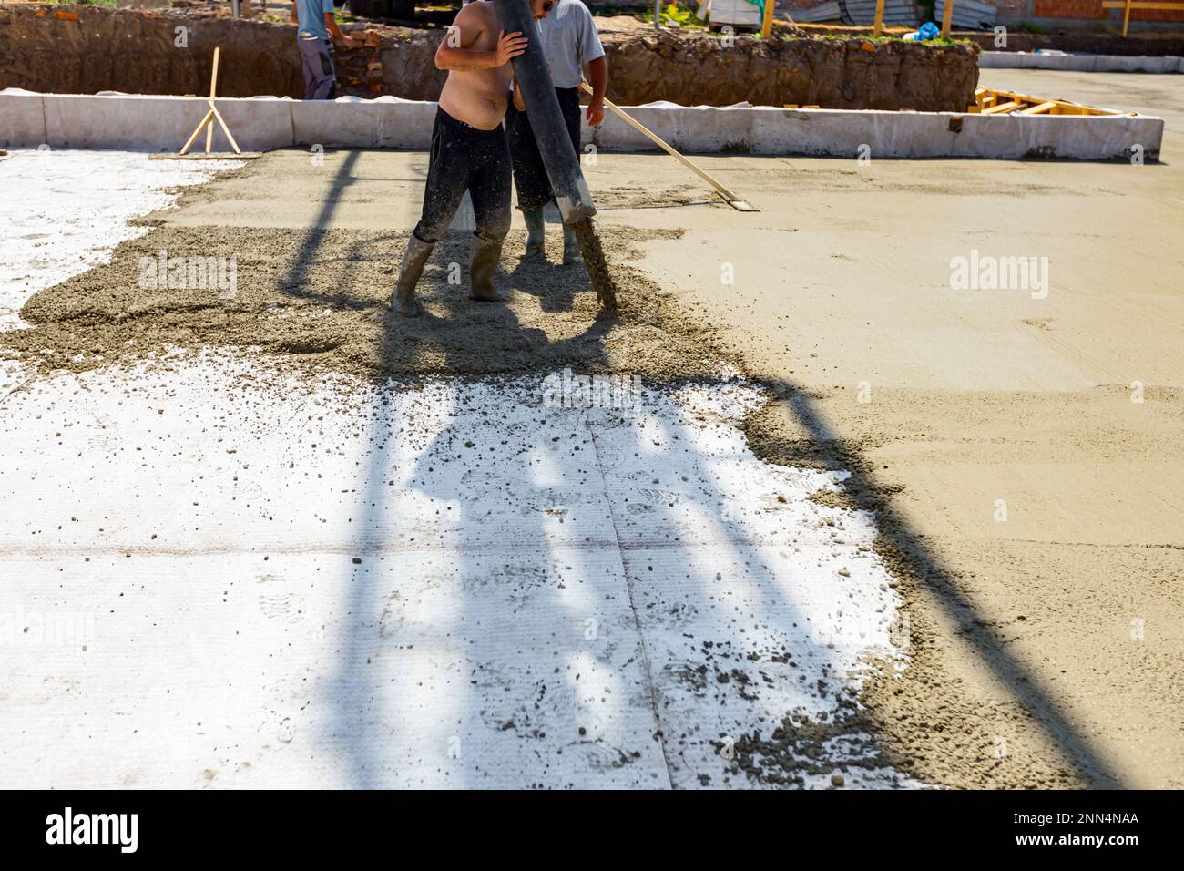 Construction worker is directing the pump tube on right direction ...