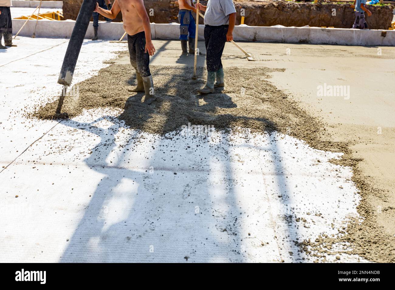 Construction worker is directing the pump tube on right direction ...