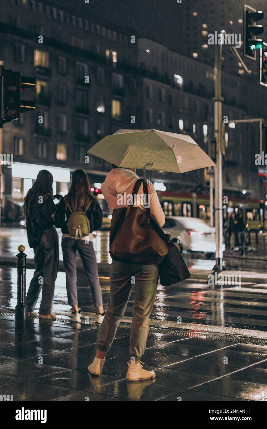 woman with umbrella on rainy city street at night Stock Photo - Alamy