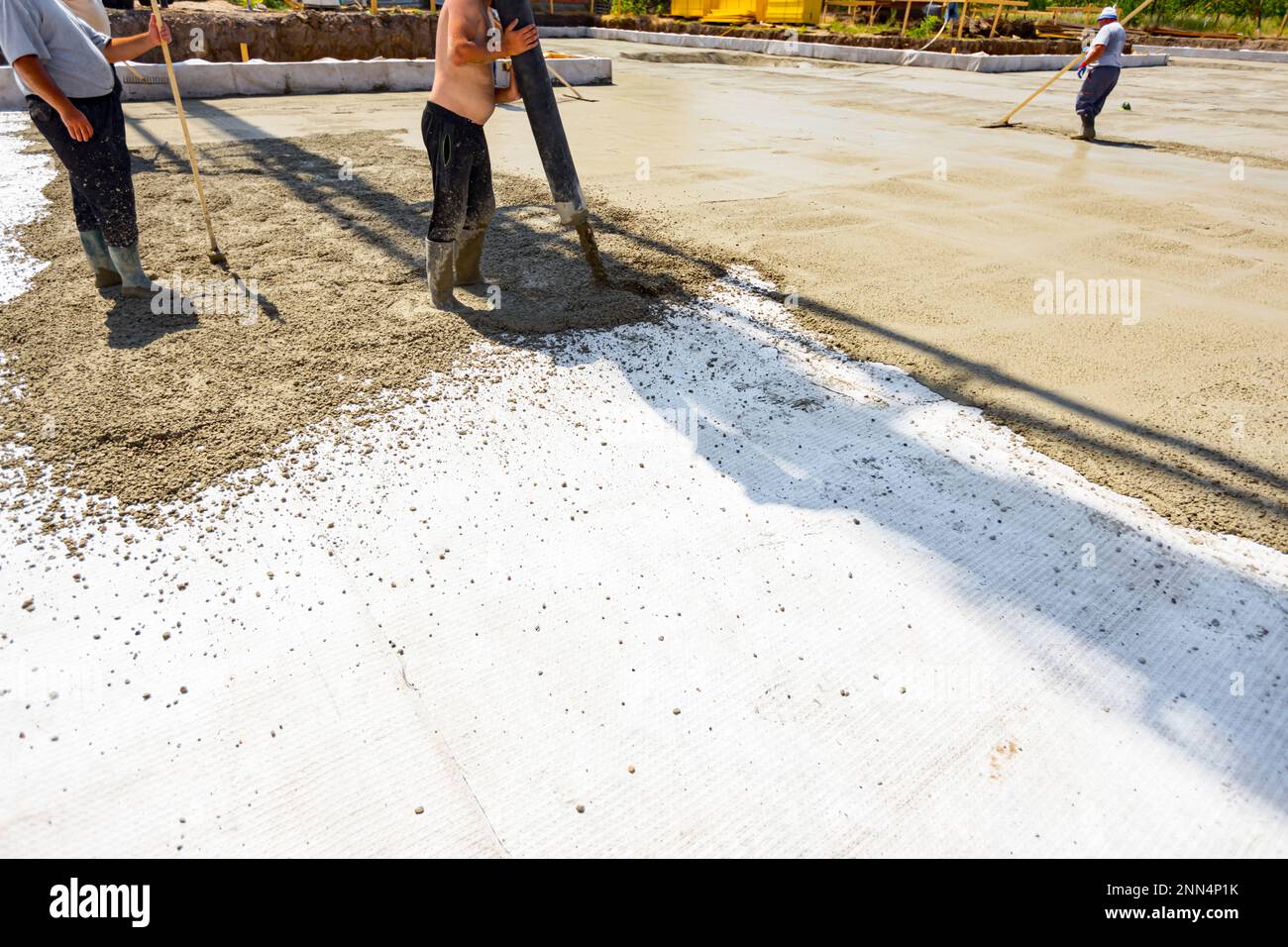 Construction worker is directing the pump tube on right direction ...