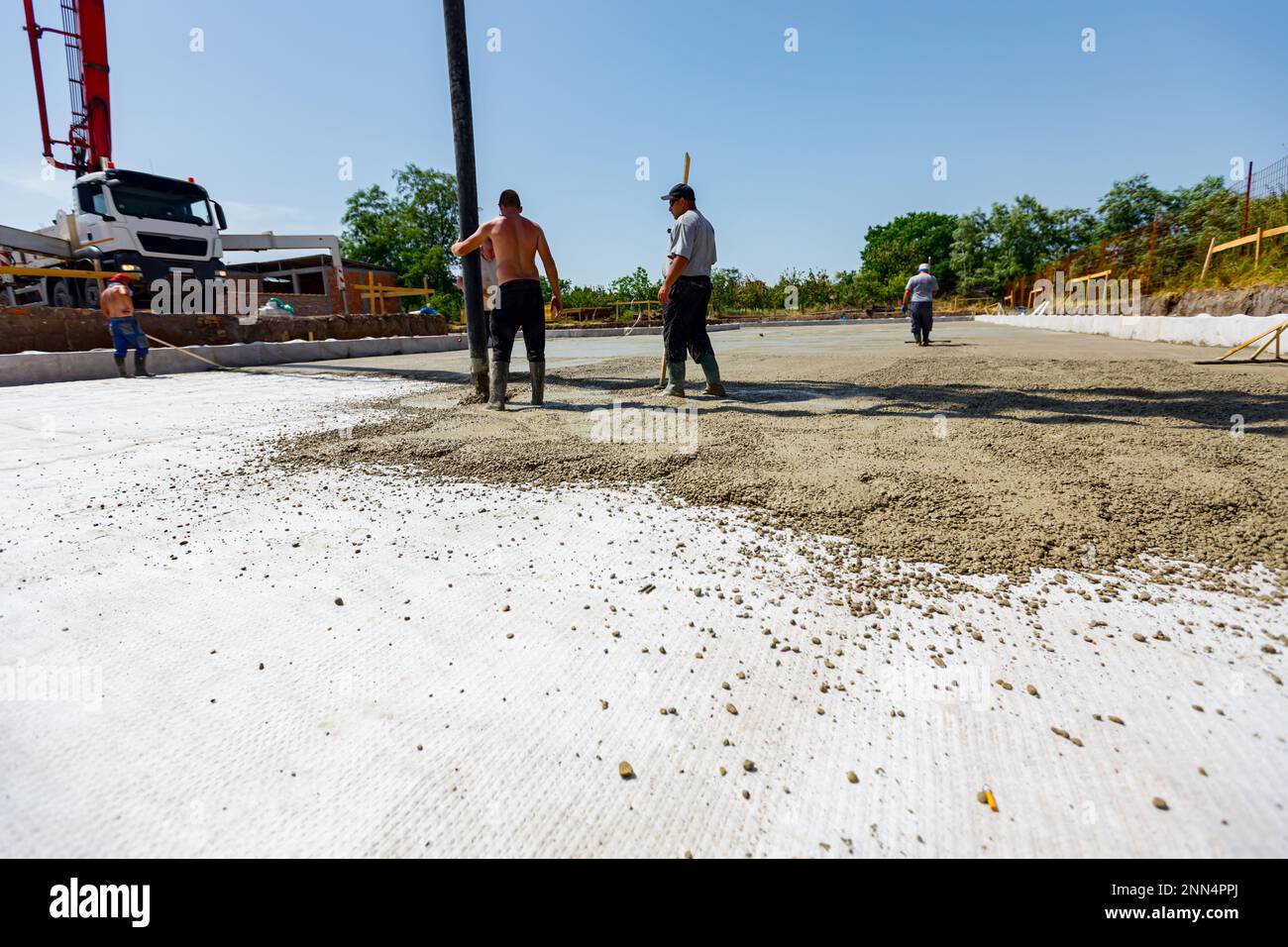 Construction worker is directing the pump tube on right direction ...