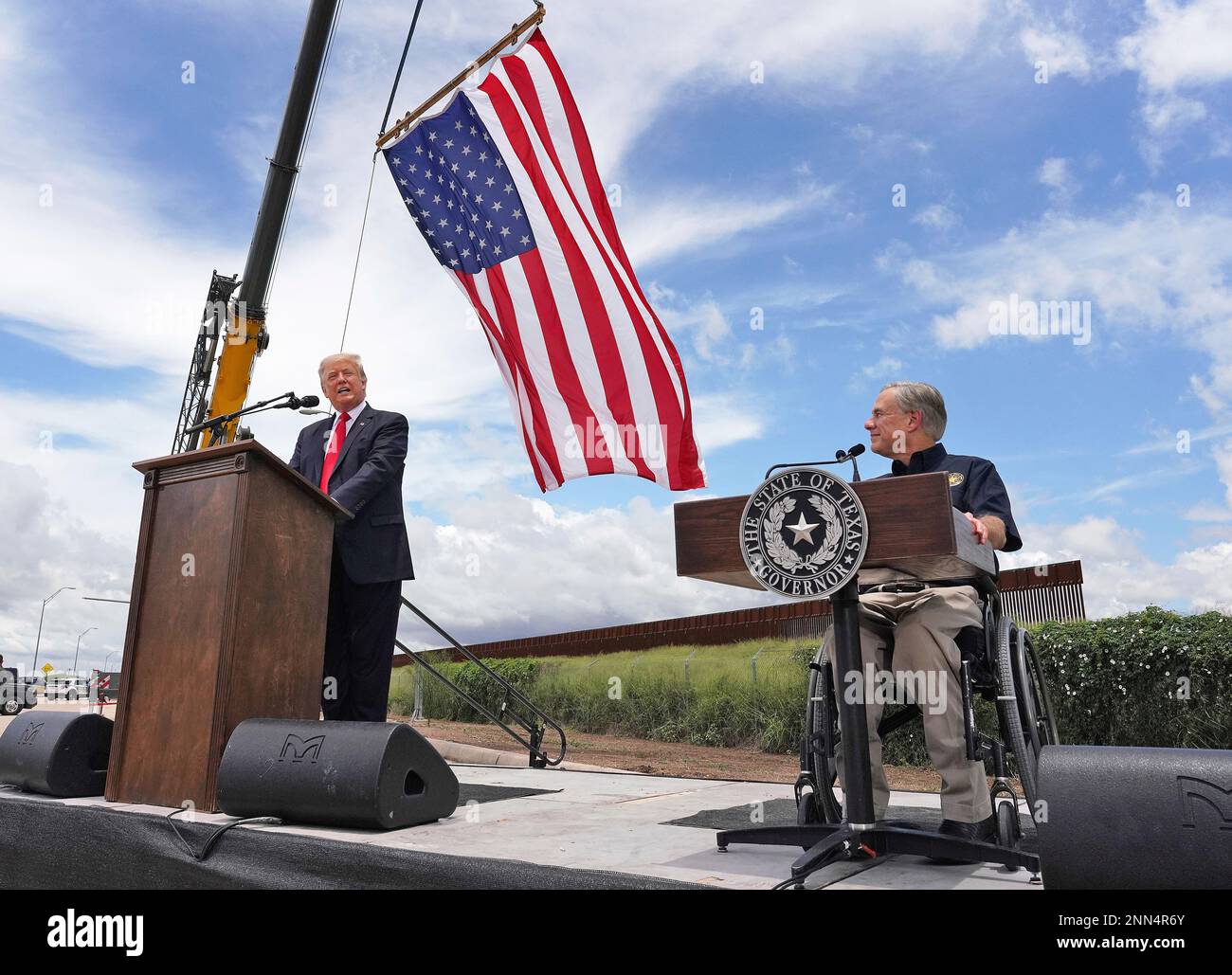 Former President Donald Trump and Texas Gov. Greg Abbott speak near a ...