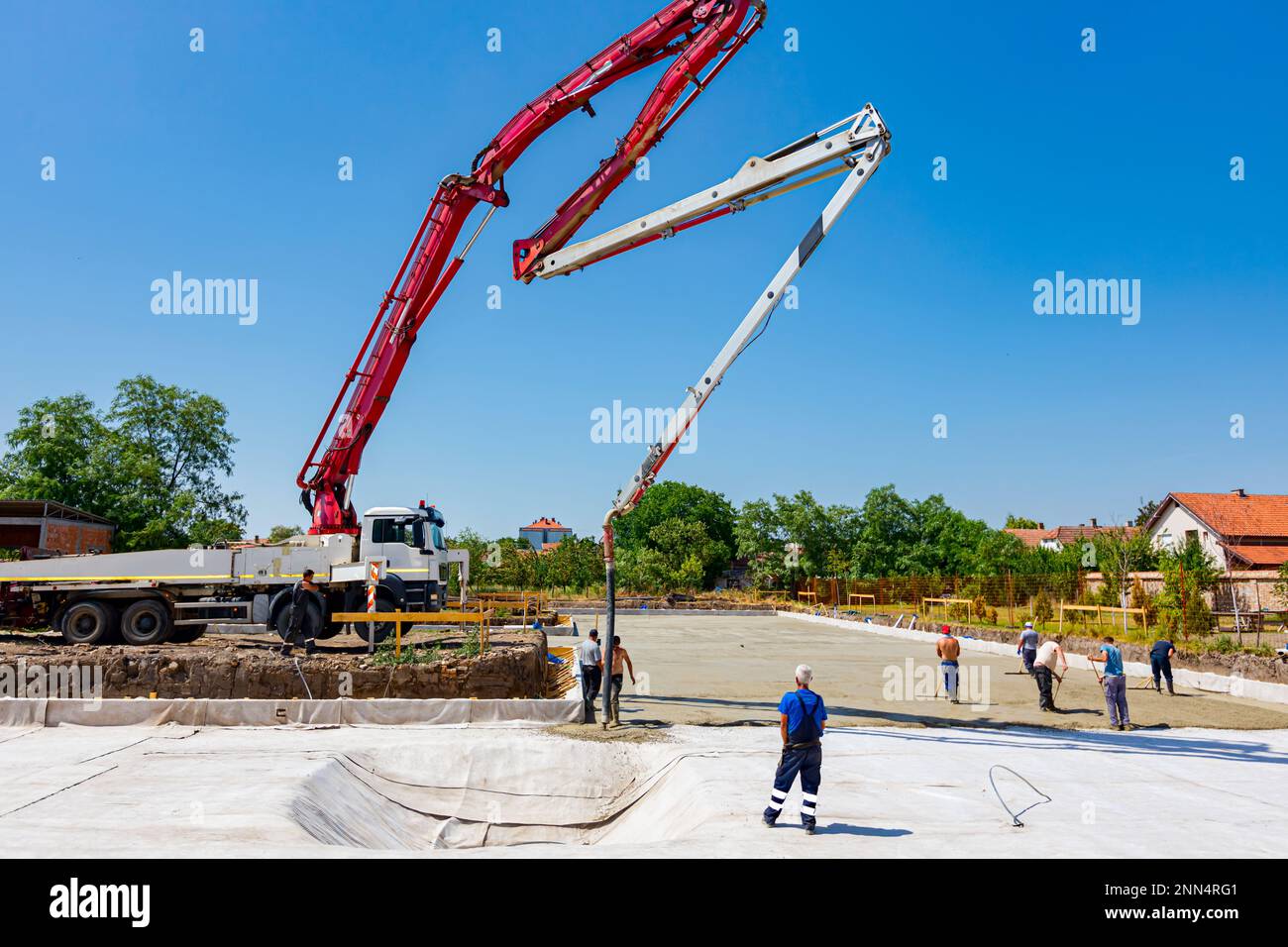 Construction site, mixer truck pouring concrete into pump machine ...