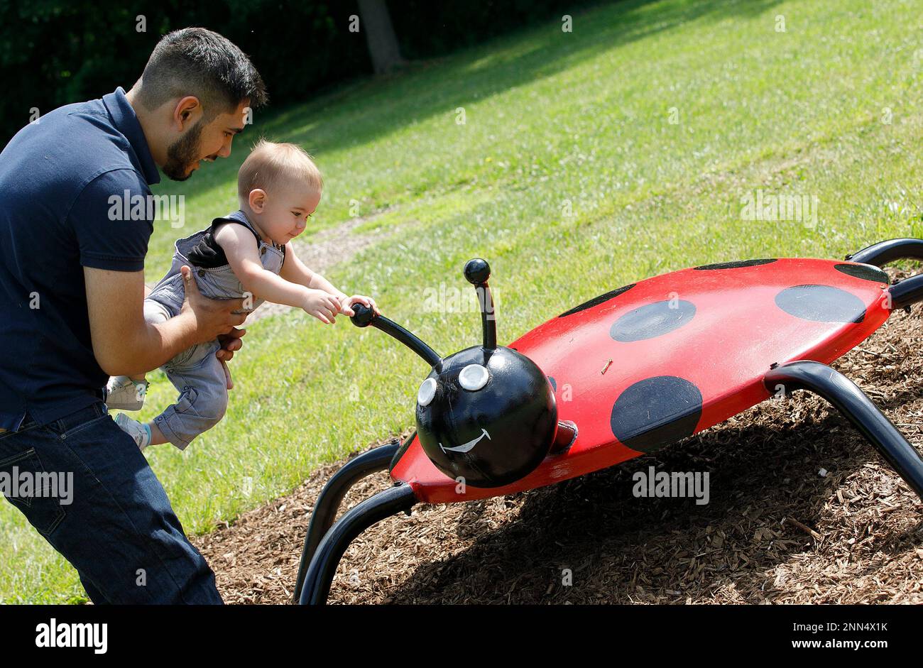 Rory Persaud, of Meriden, Conn.,holds son Micah, 1, who grabs for the ...