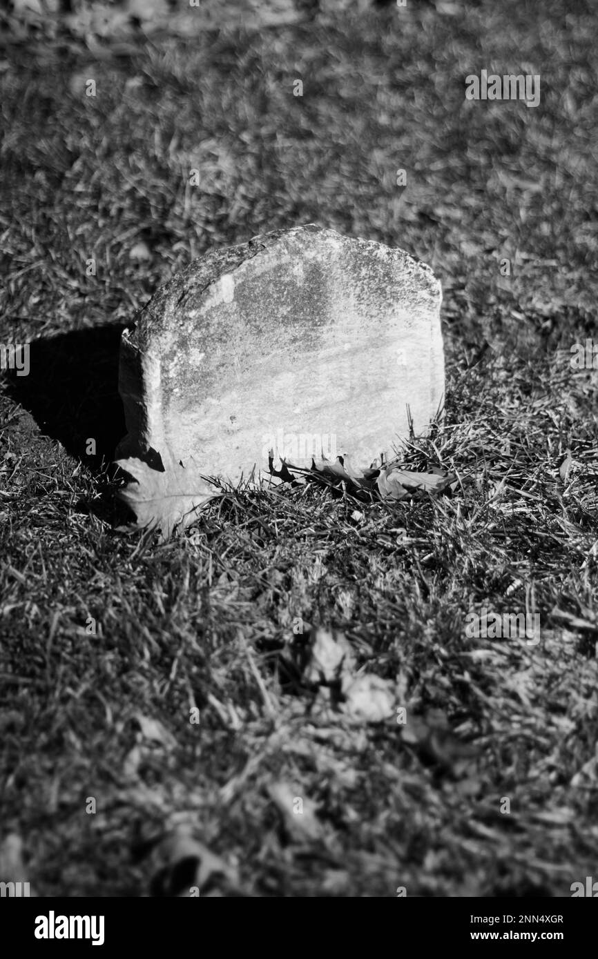 A worn and weathered old tombstone with a blank epitaph and room for ...