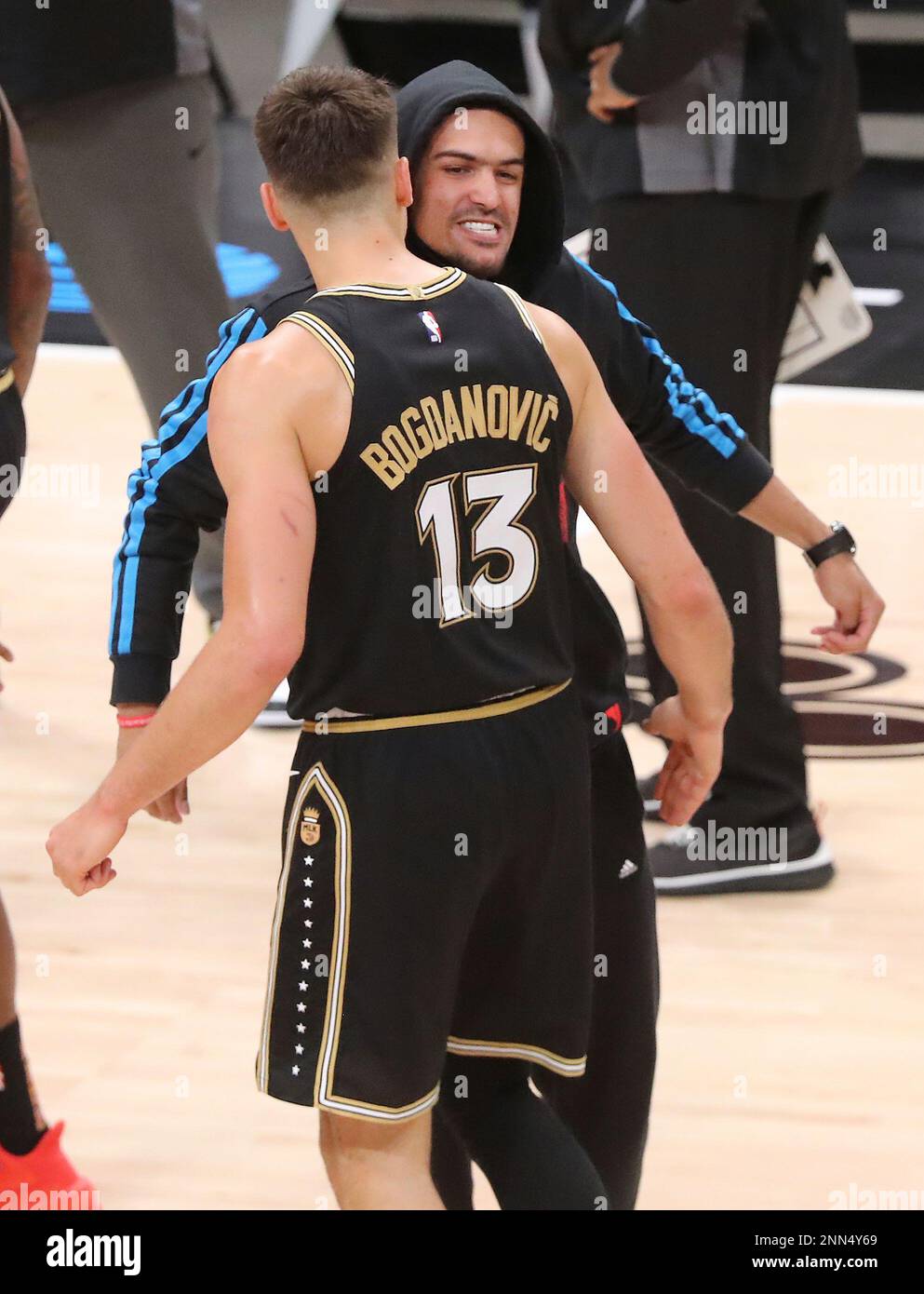 Injured Atlanta Hawks guard Trae Young gives Bogdan Bogdanovic a chest ...