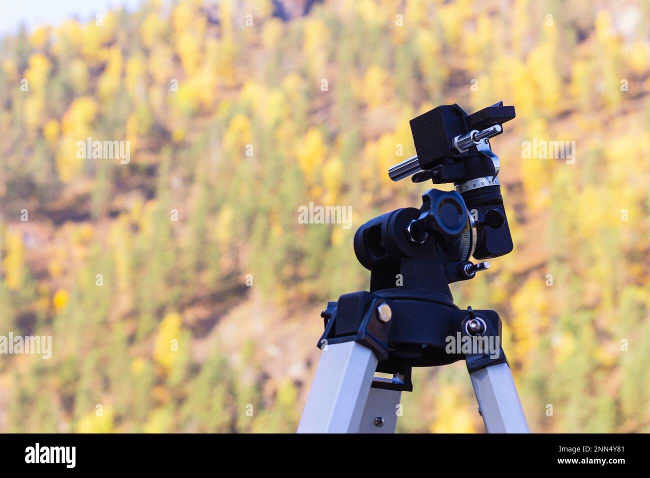 Camera tripod on natural background outdoors, selective focus with copy ...