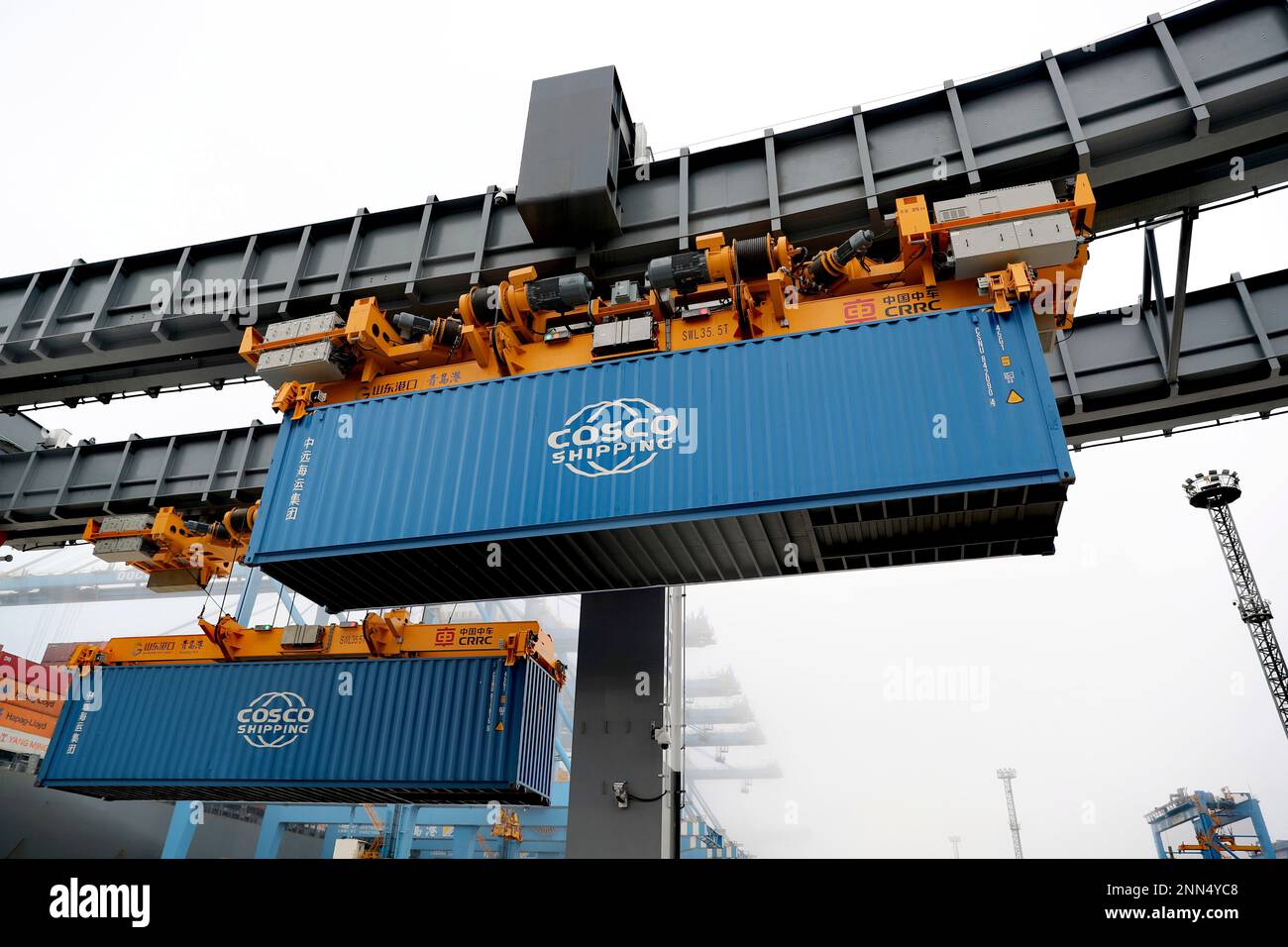 A carriage moves a container on the elevated track to an automated ...
