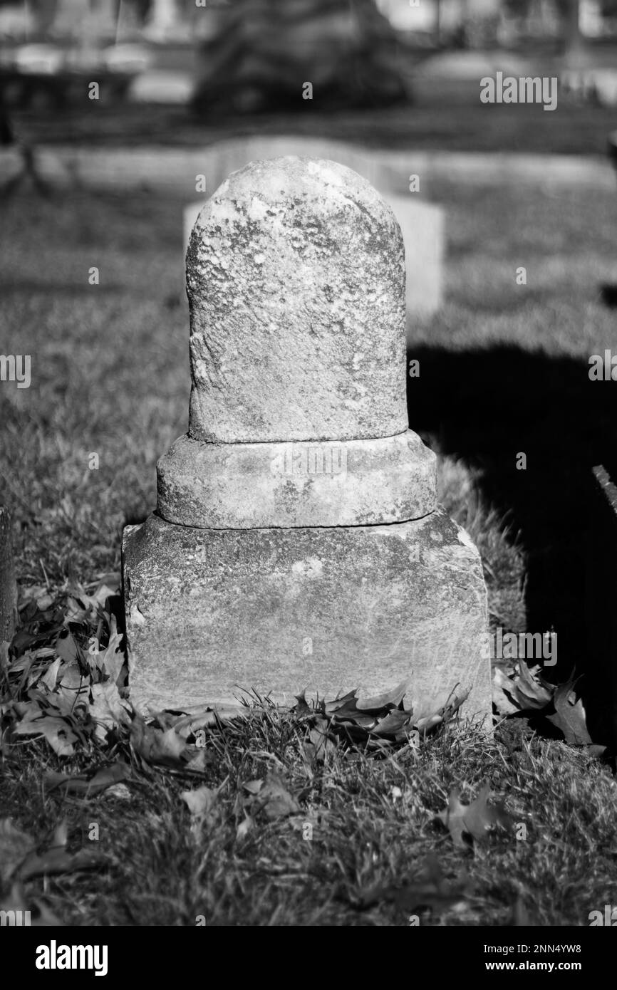 A worn and weathered old tombstone with a blank epitaph and room for ...