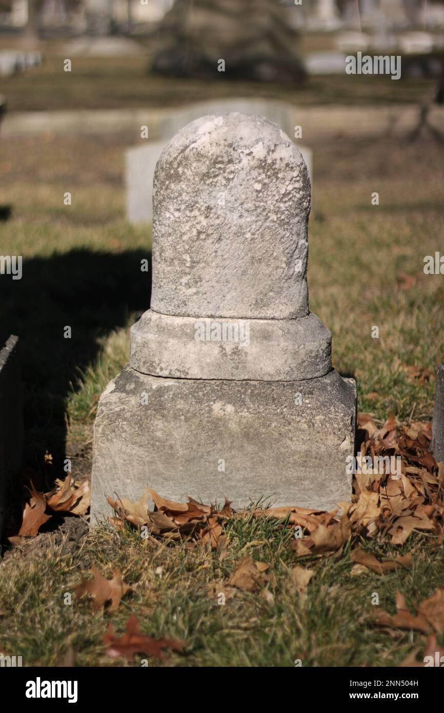 A worn and weathered old tombstone with a blank epitaph and room for ...