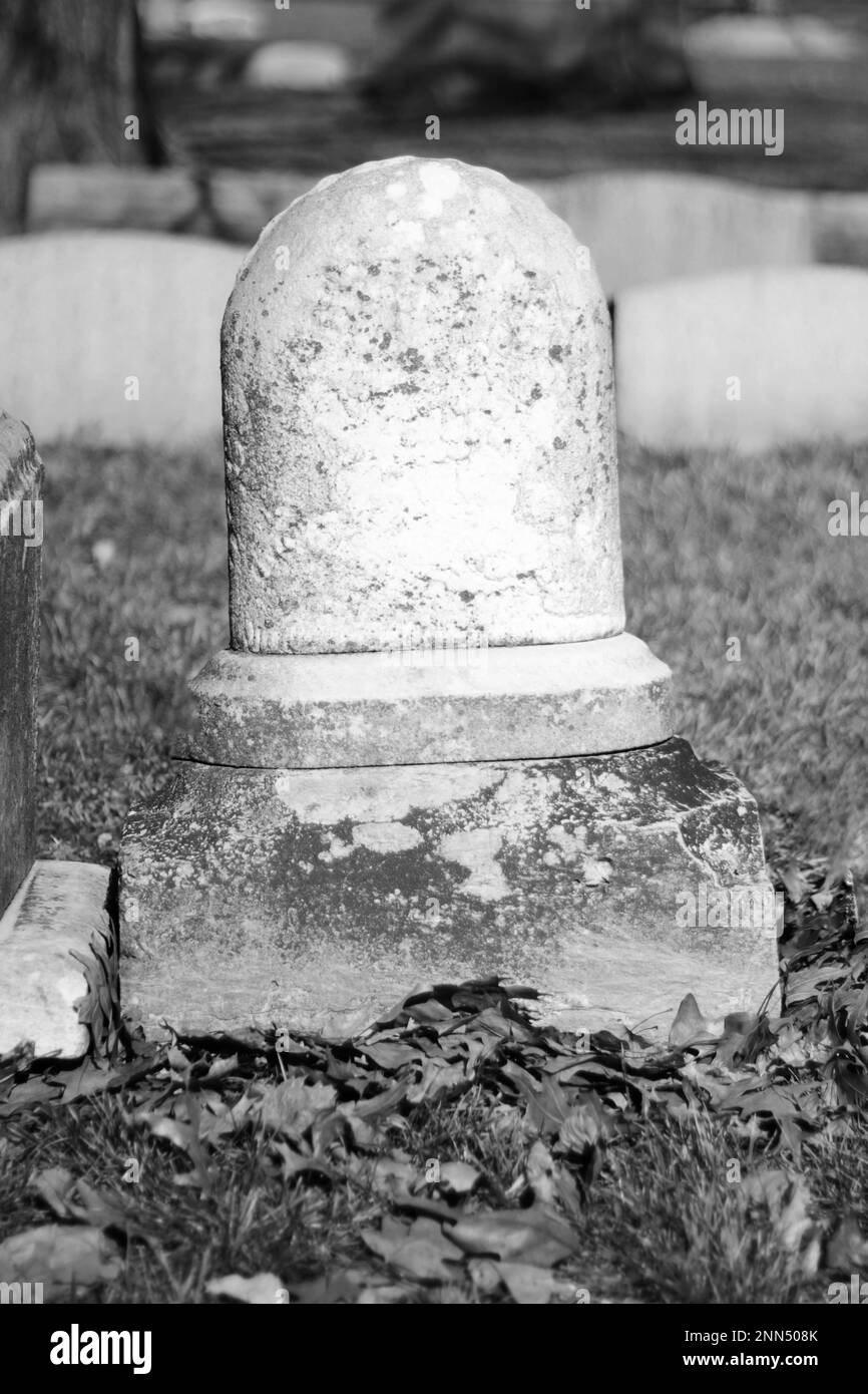 A worn and weathered old tombstone with a blank epitaph and room for ...