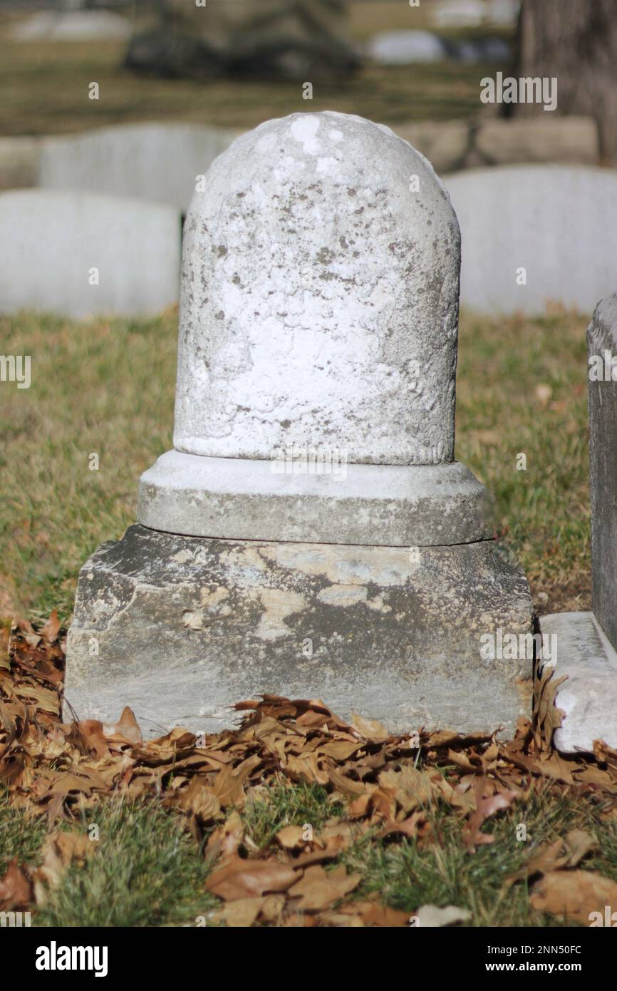 A worn and weathered old tombstone with a blank epitaph and room for ...