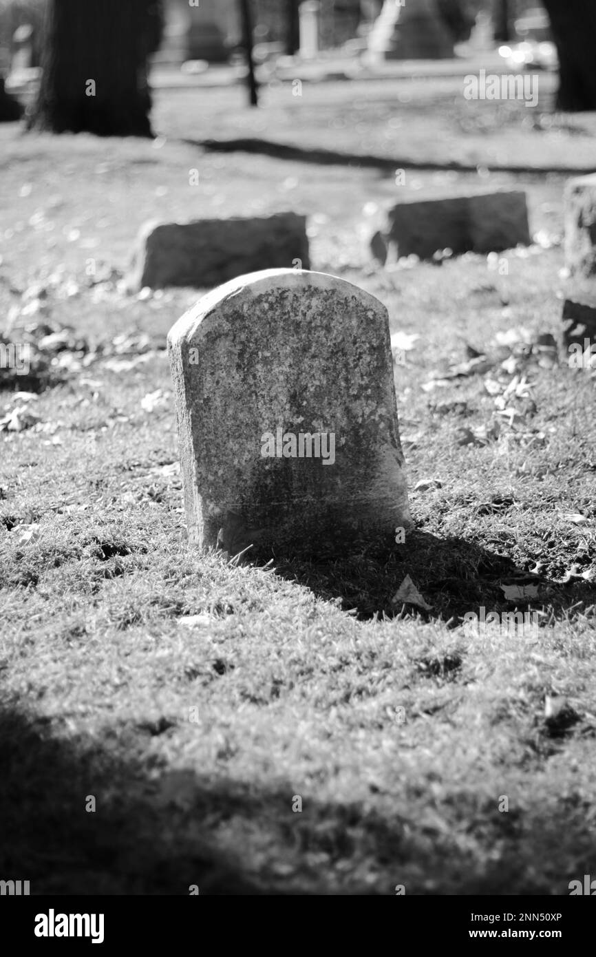 A worn and weathered old tombstone with a blank epitaph and room for ...