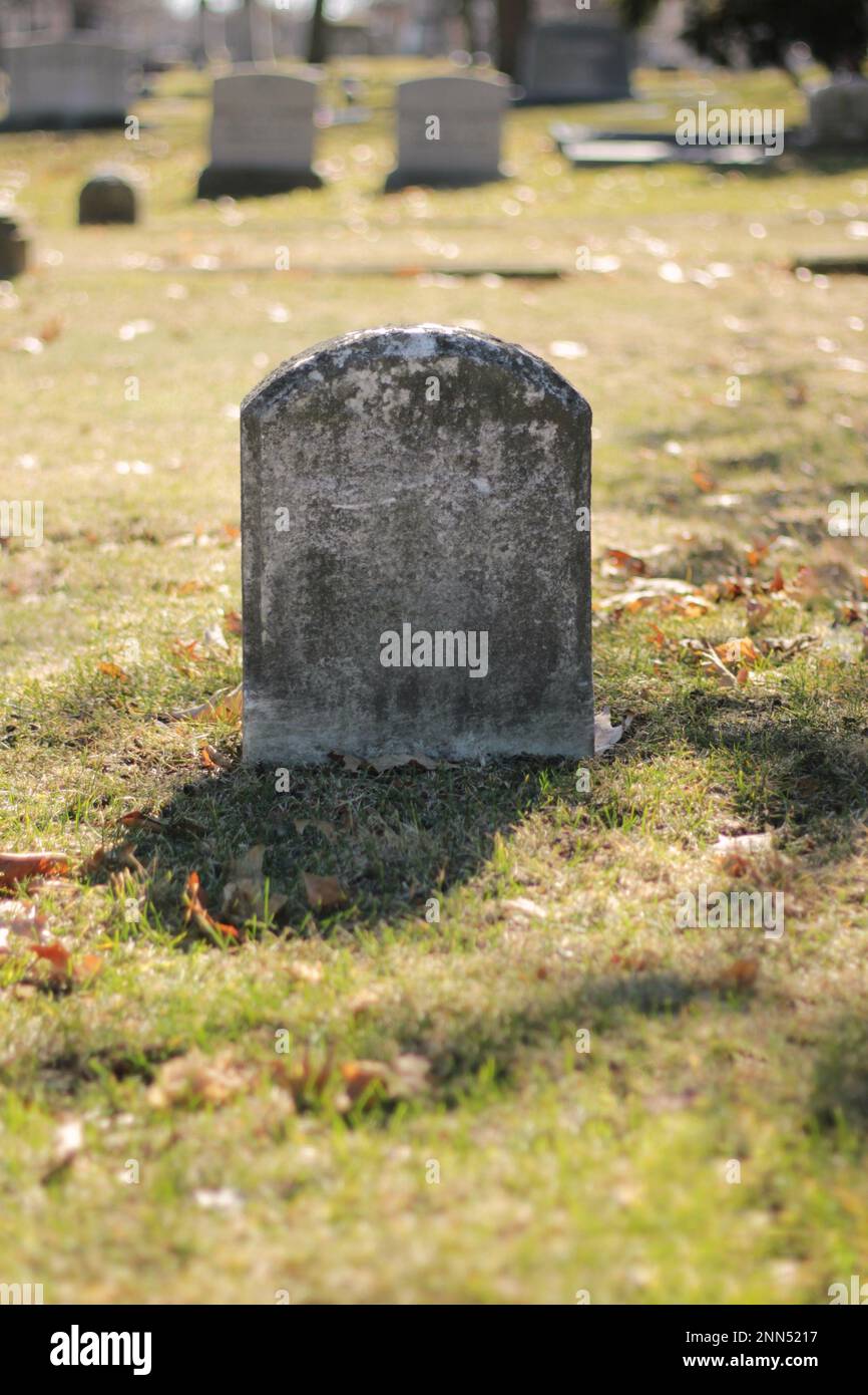 A worn and weathered old tombstone with a blank epitaph and room for ...