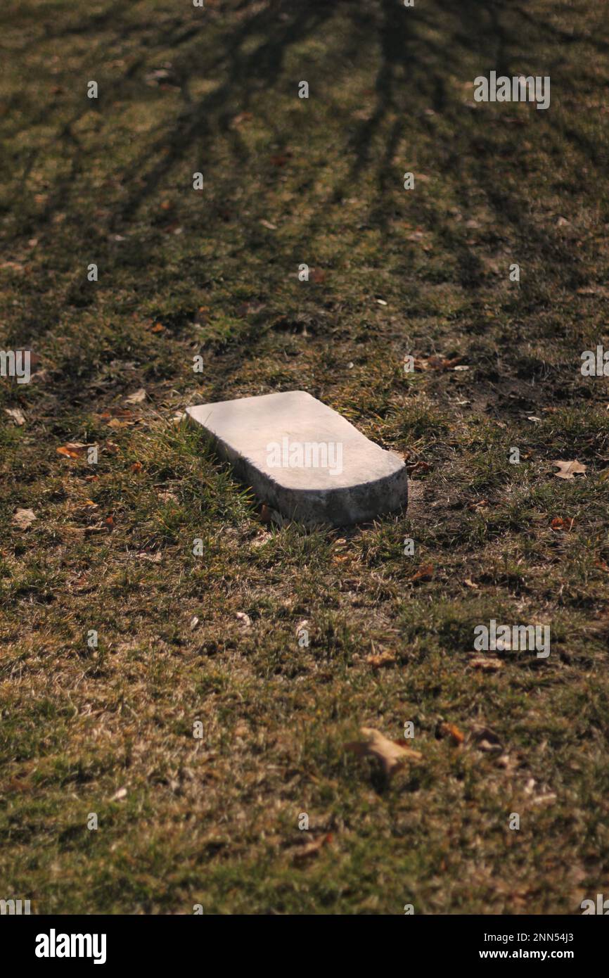 An abandoned vintage tombstone laying on the ground Stock Photo - Alamy