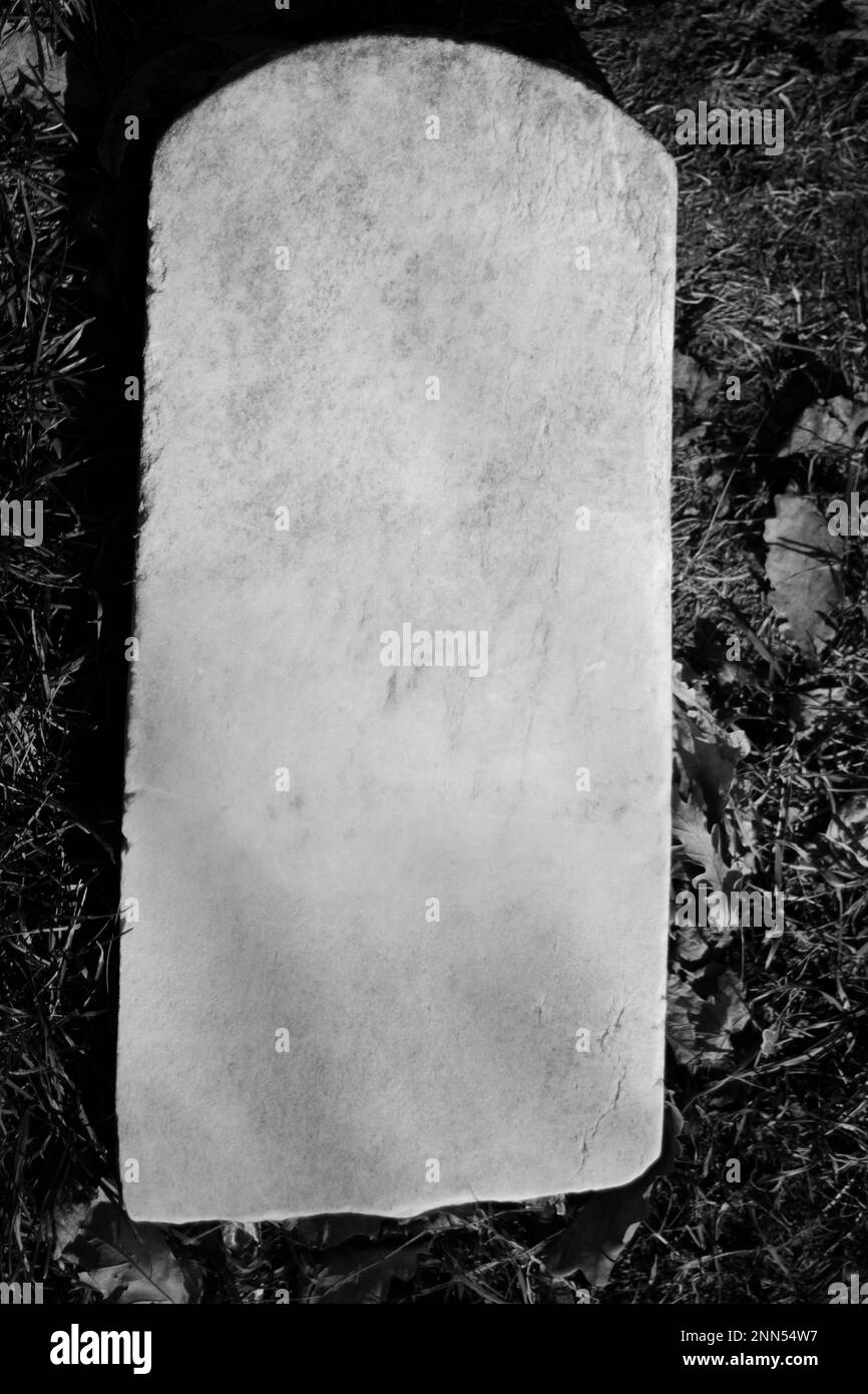 A worn and weathered old tombstone with a blank epitaph and room for ...